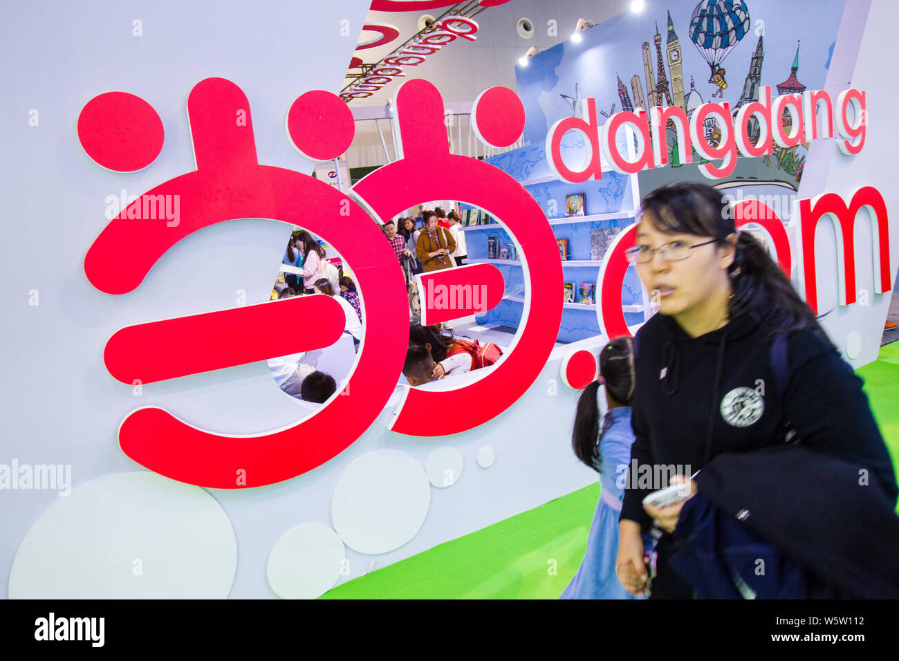 --FILE--Visitors walk past the stand of Chinese popular online ...