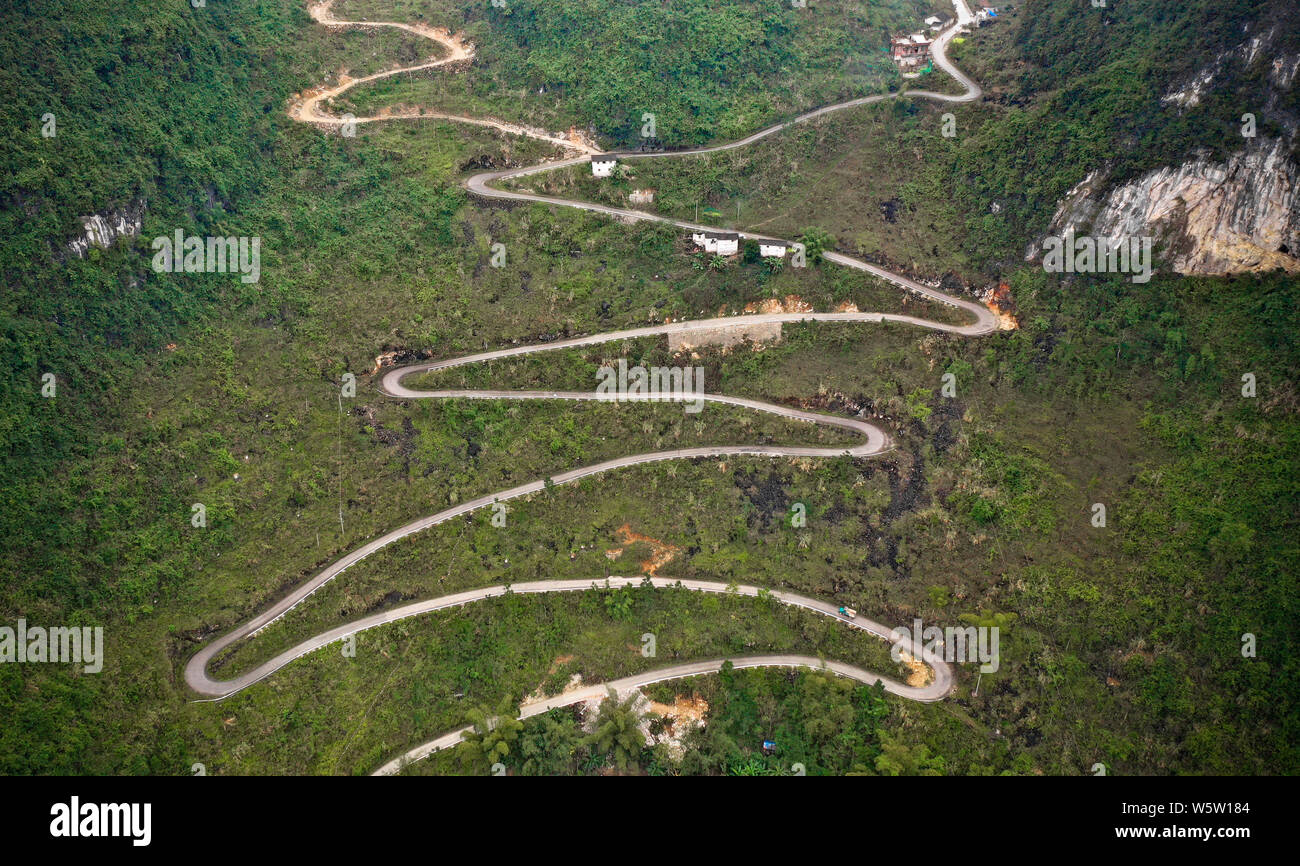 Aerial view of a winding mountain road around mountains in Du'an Yao ...