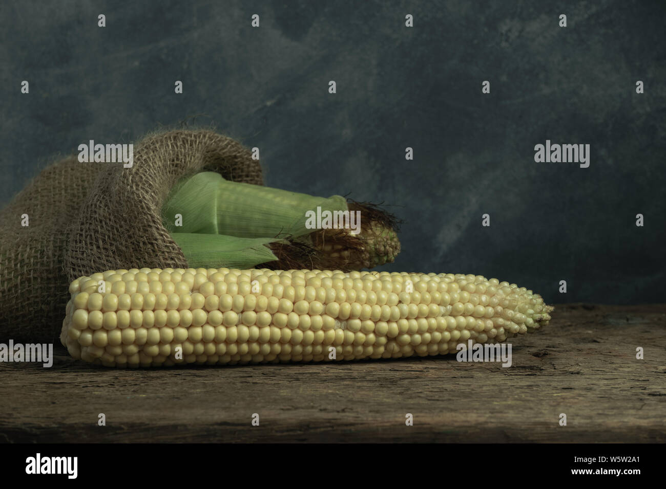 Fresh Sweet corn in bag on a old oak wooden table and beautiful grey ...