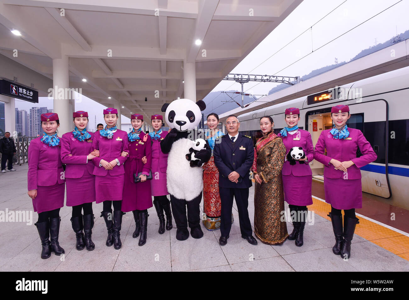 Chinese train attendants pose with a worker dressed in giant panda ...
