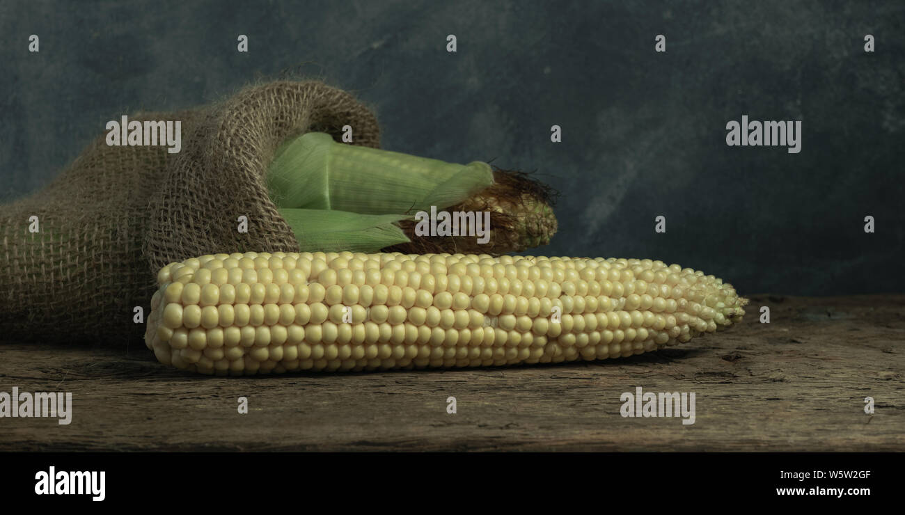 Fresh Sweet corn in bag on a old oak wooden table and beautiful grey ...