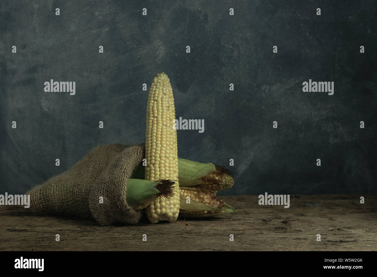 Fresh Sweet corn in bag on a old oak wooden table and beautiful grey ...