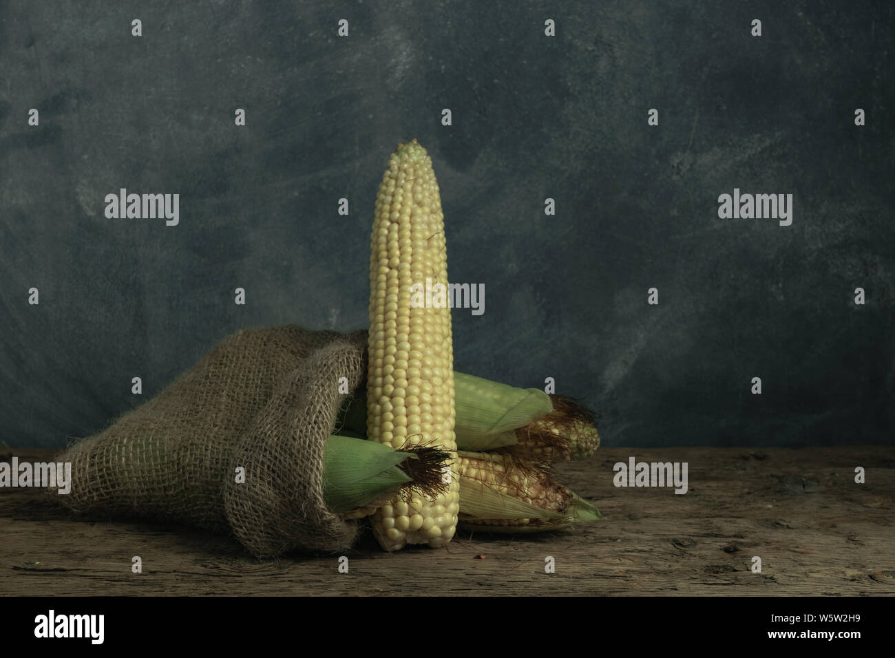 Fresh Sweet corn in bag on a old oak wooden table and beautiful grey ...