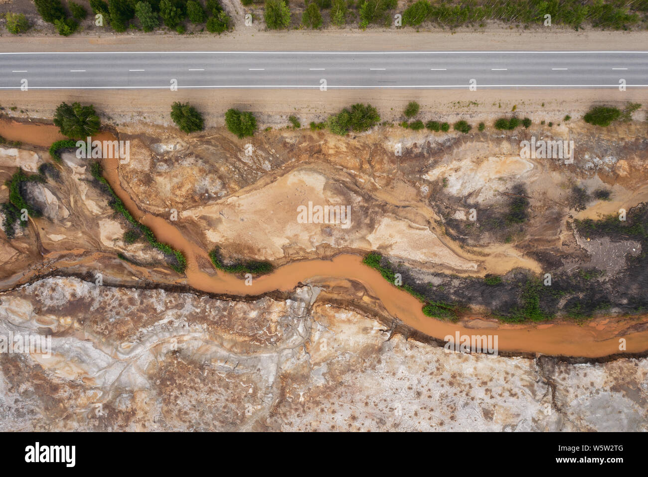 Aerial top down view; drone flying over a very polluted river with ...
