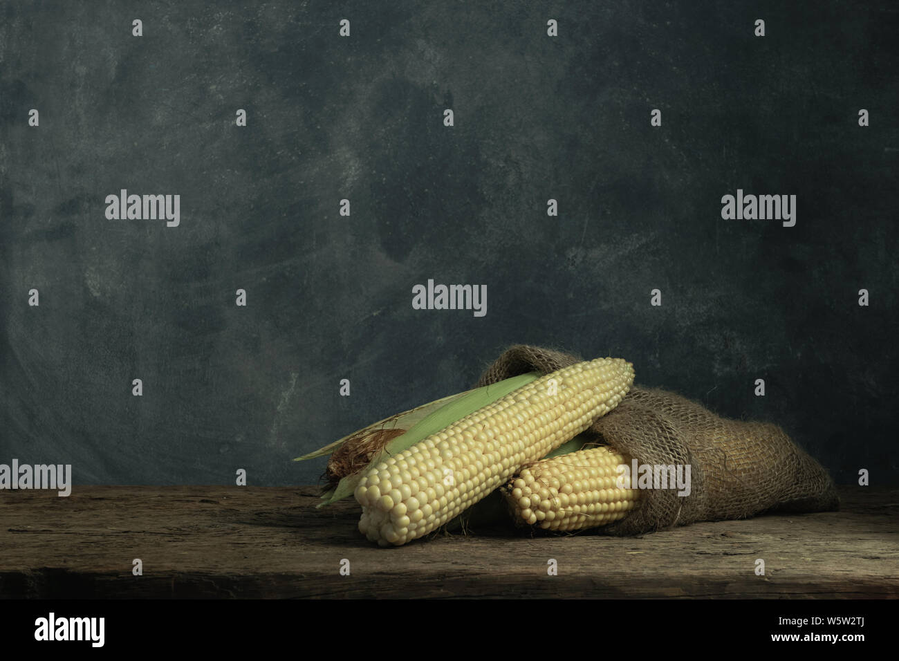 Fresh Sweet corn in bag on a old oak wooden table and beautiful grey ...