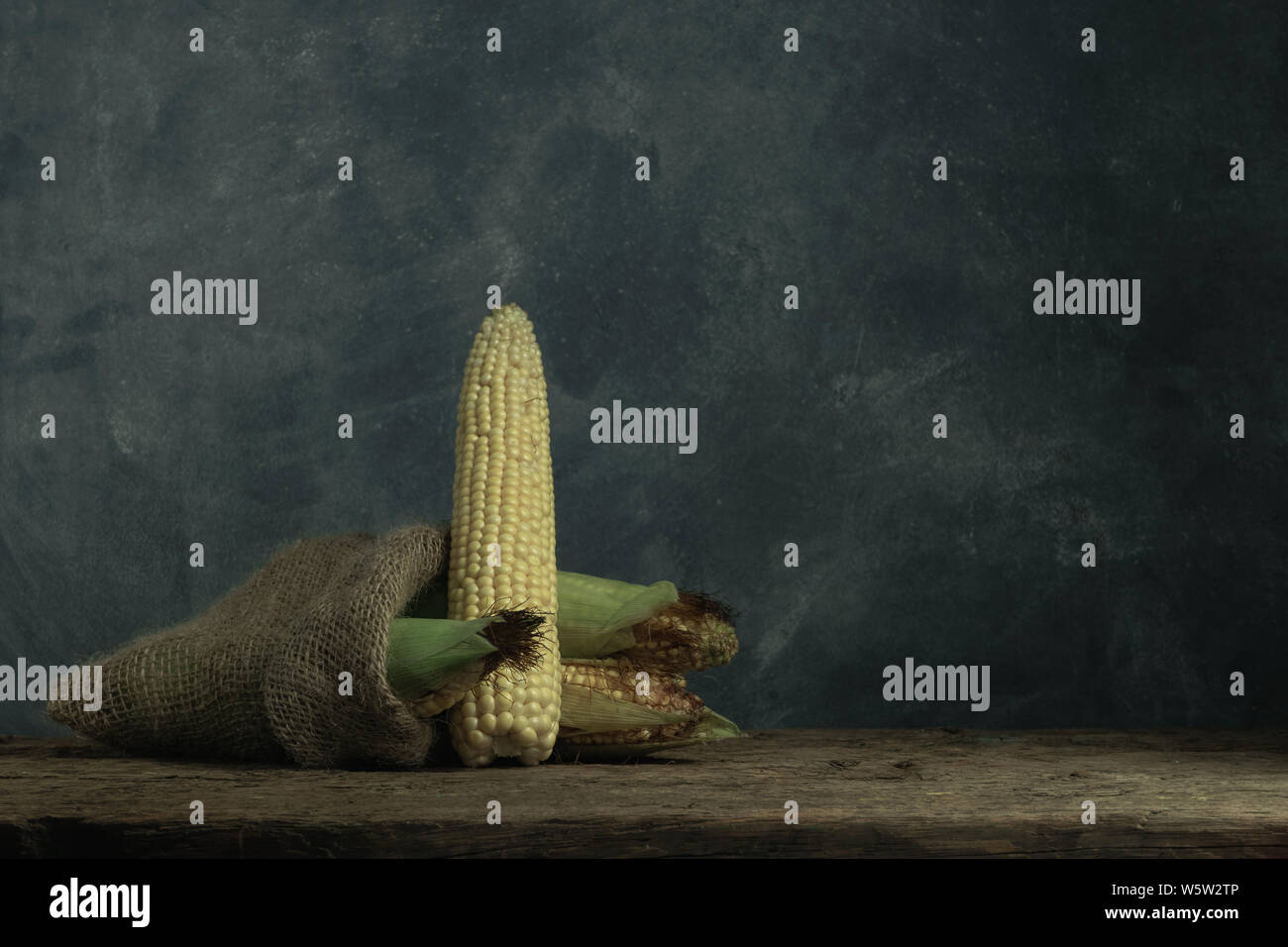 Fresh Sweet corn in bag on a old oak wooden table and beautiful grey ...