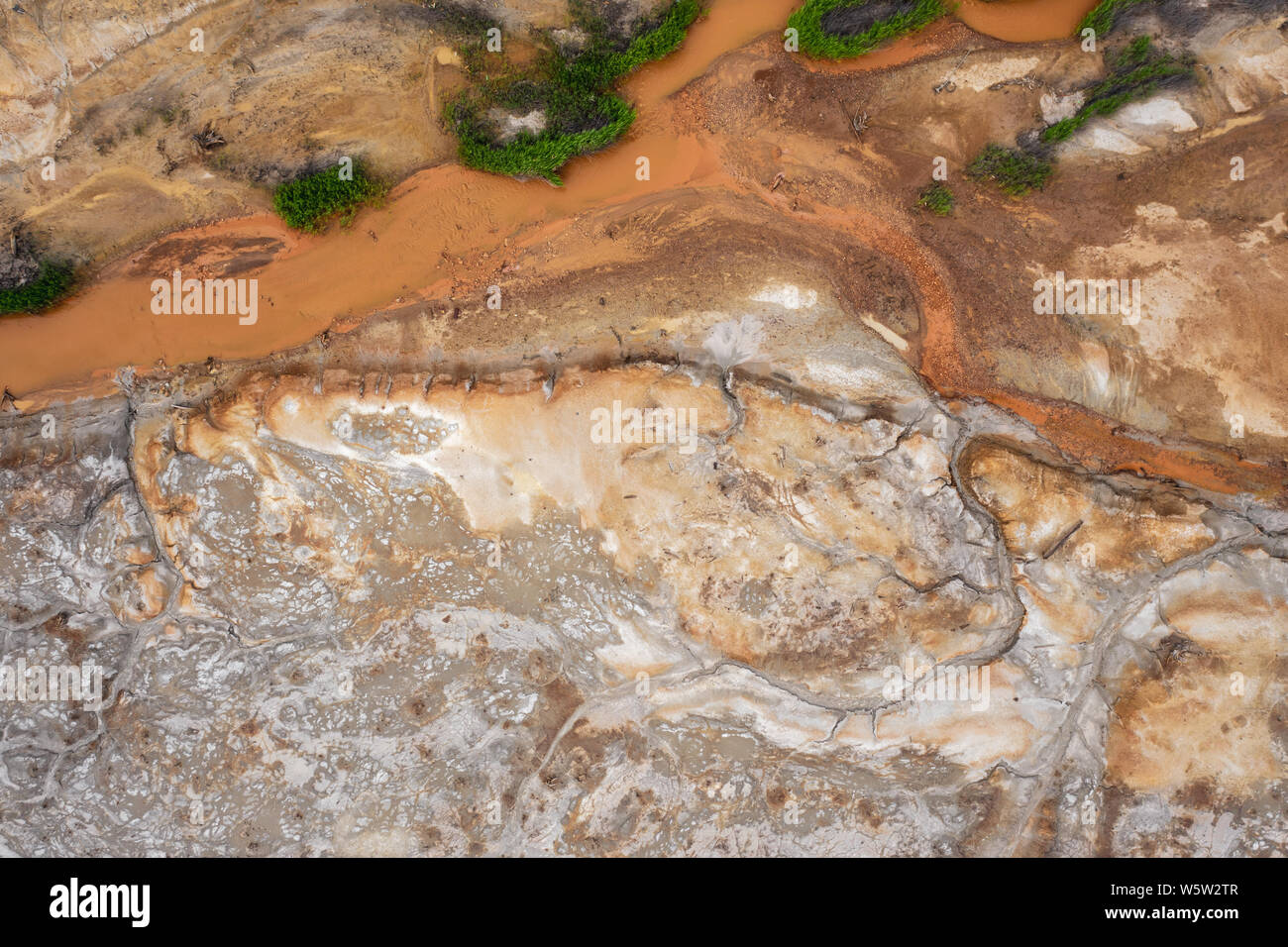Aerial view; drone flying forward over a polluted river with destroyed ...