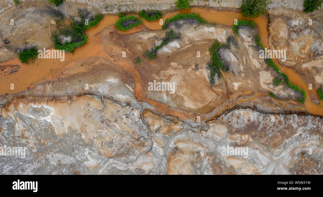 Aerial top down view; drone flying over a very polluted river with ...