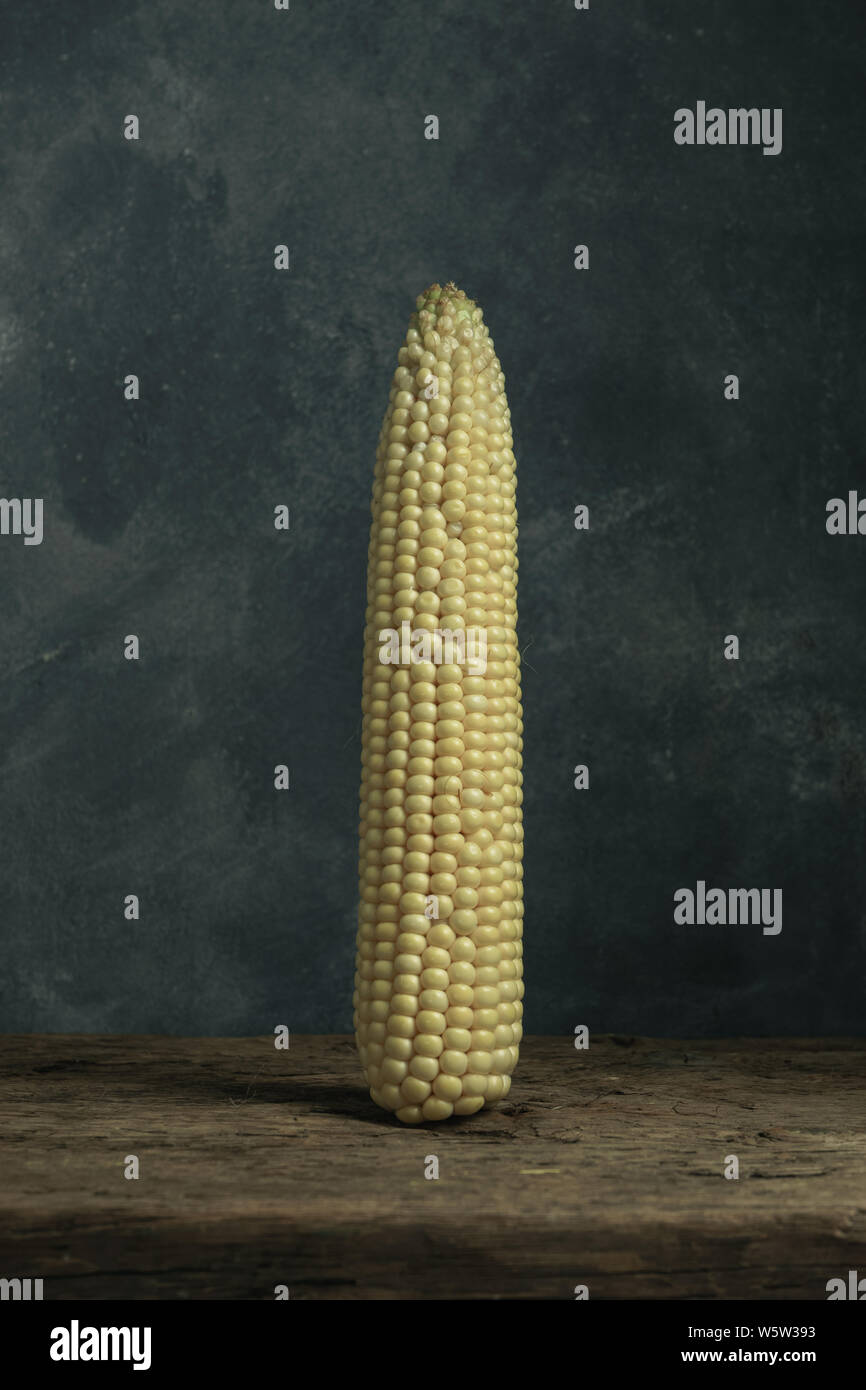 Fresh Sweet corn on a old oak wooden table and beautiful grey wall ...