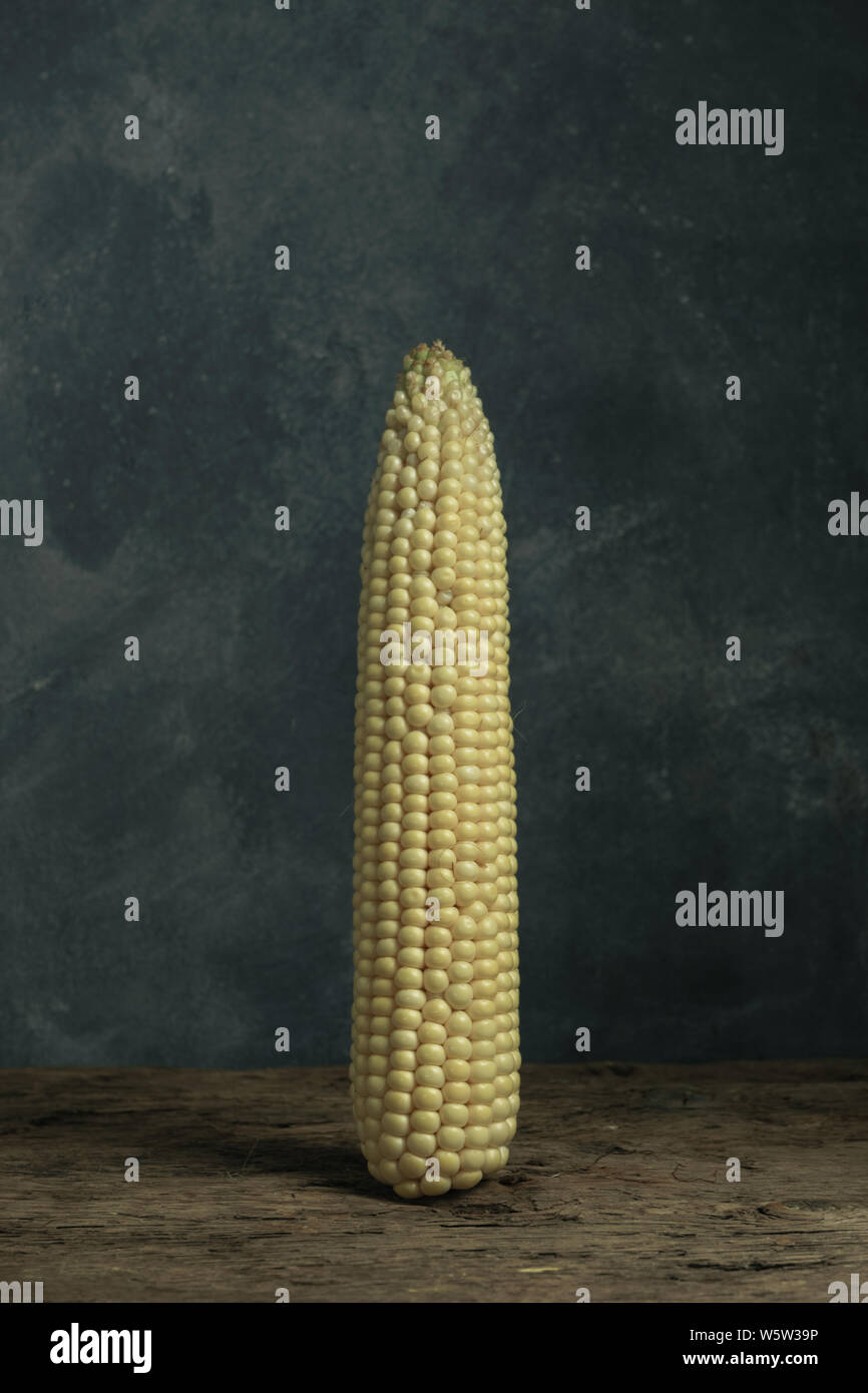 Fresh Sweet corn on a old oak wooden table and beautiful grey wall ...