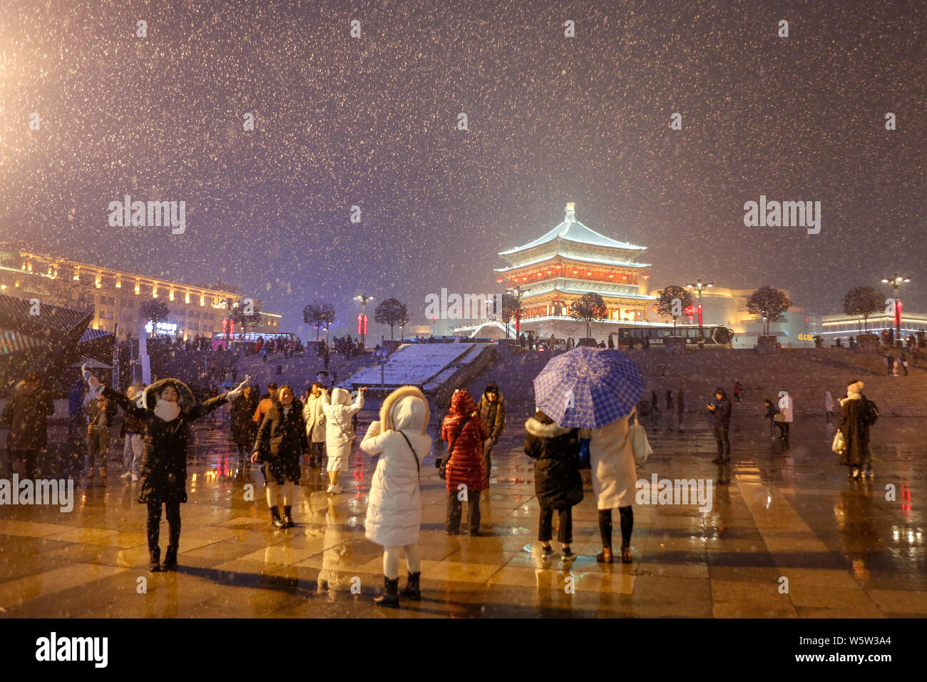 People gather at the Bell and Clock Tower Square in snow in Xi'an city ...