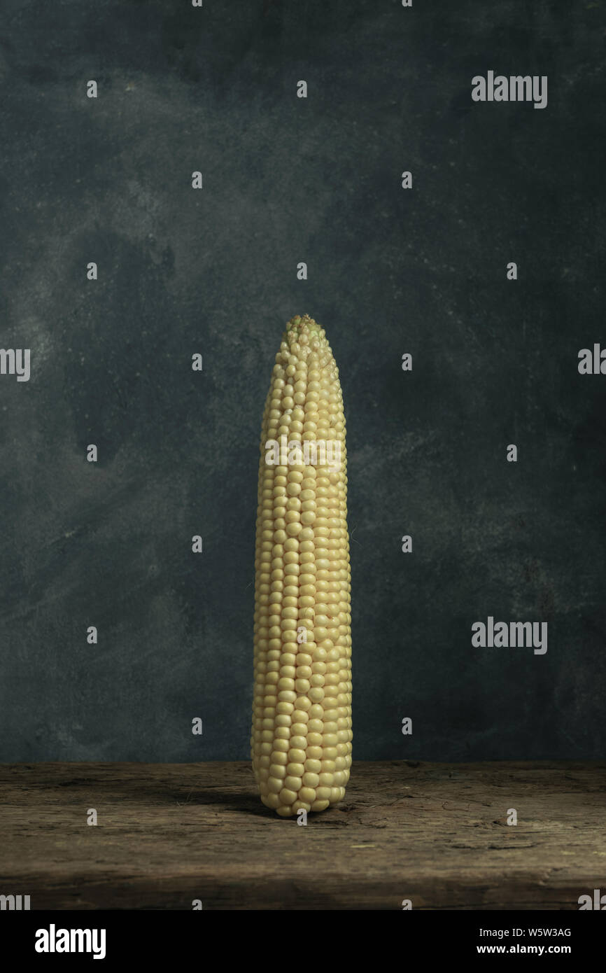 Fresh Sweet corn on a old oak wooden table and beautiful grey wall ...