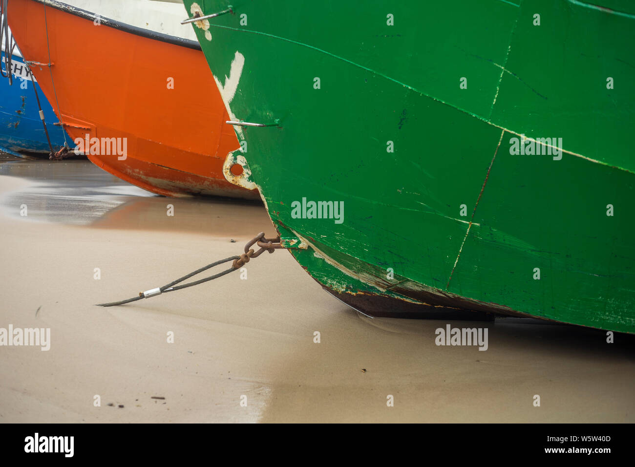 The sterns of three fishing boats lying on the beach, Chlopy, Poland ...