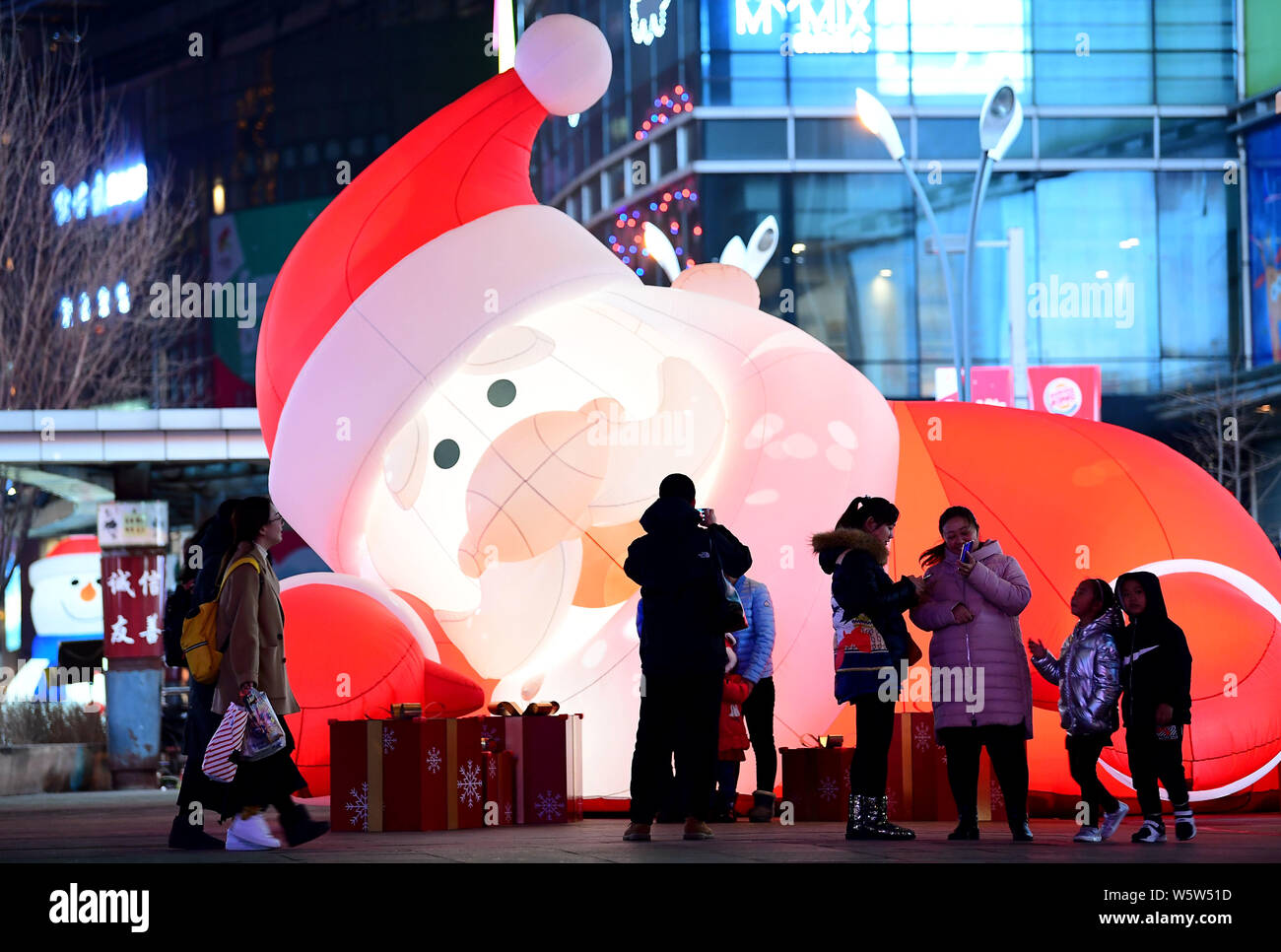 A huge illuminated decoration featuring the shape of Santa Claus is ...