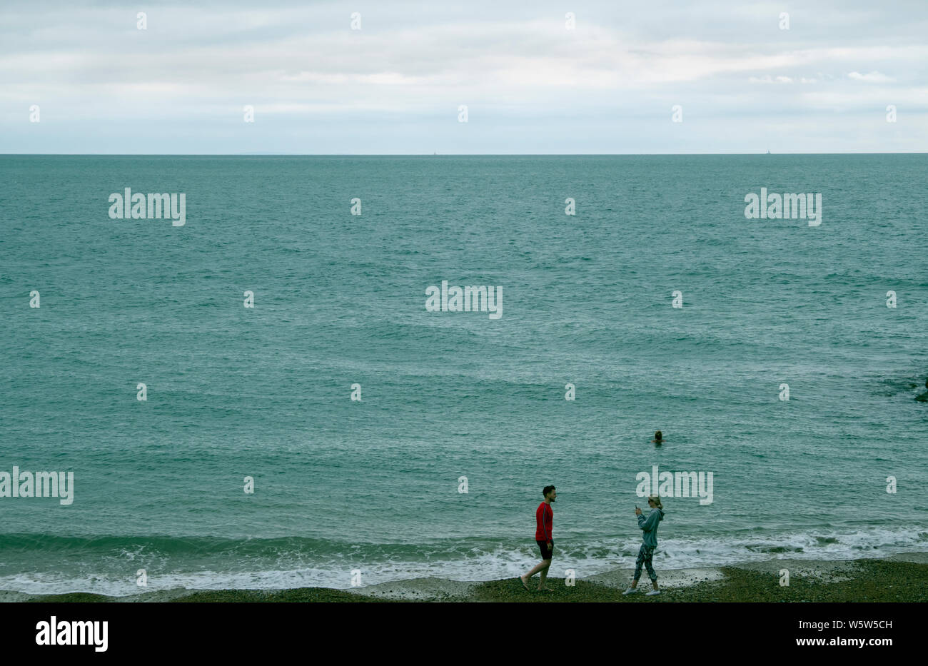Young couple on Mermaid beach in Folkestone on cloudy day Stock Photo ...