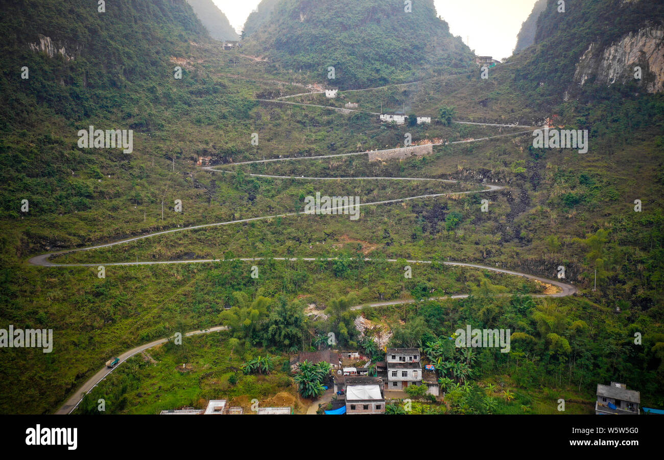 Aerial view of a winding mountain road around mountains in Du'an Yao ...