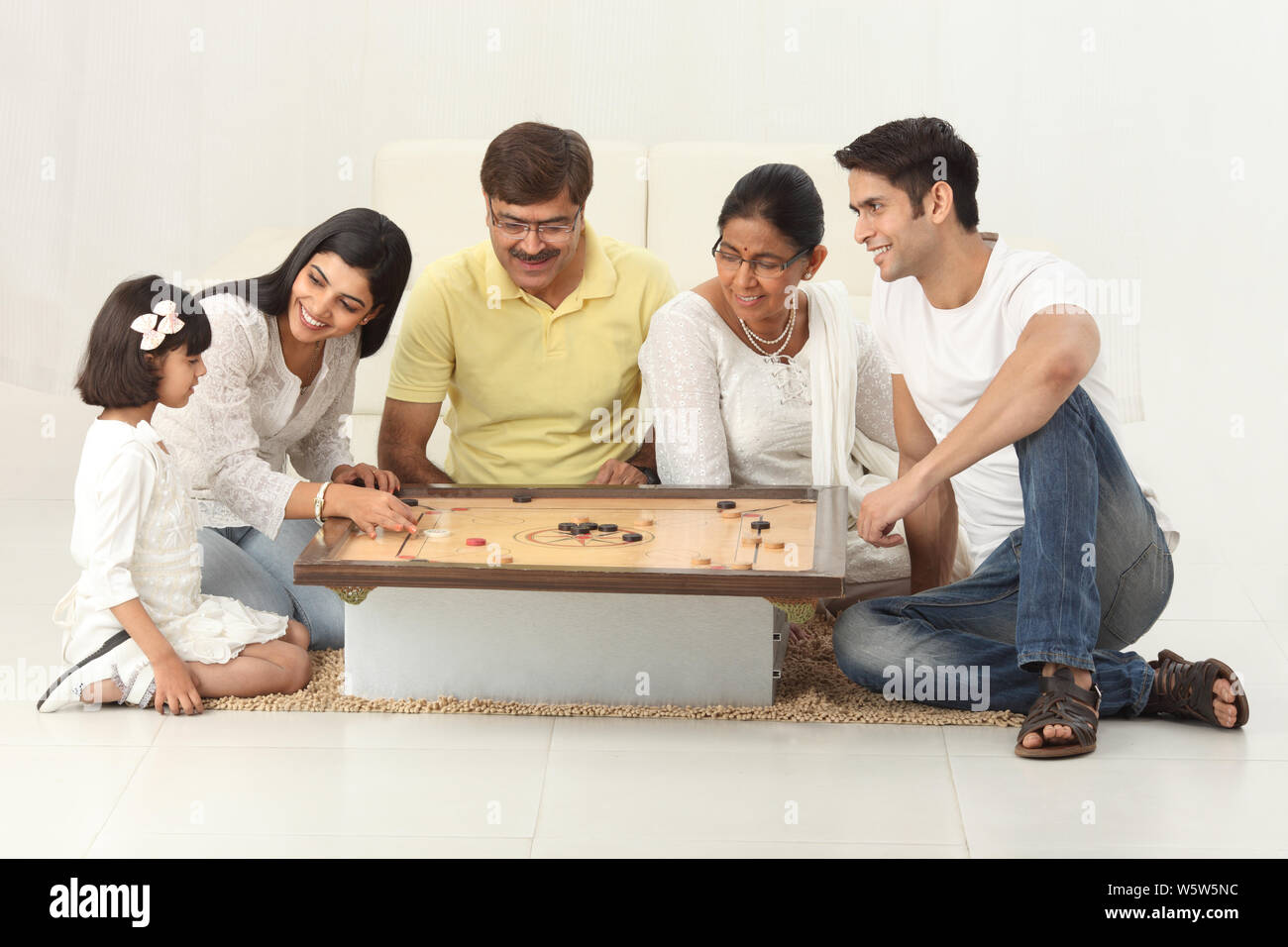 Indian family playing carom and smiling Stock Photo - Alamy
