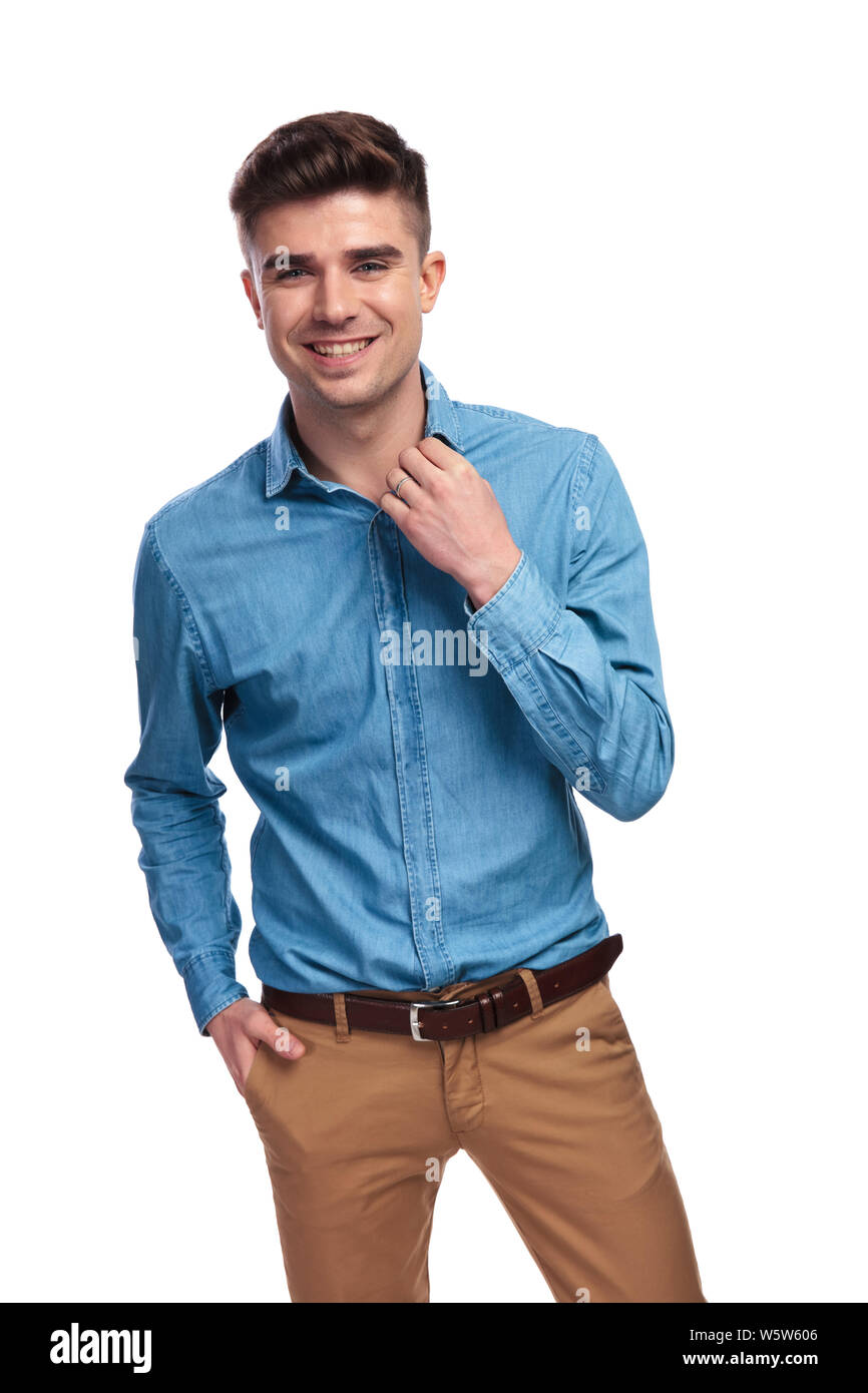 smiling young casual man fixing his collar on white background Stock ...