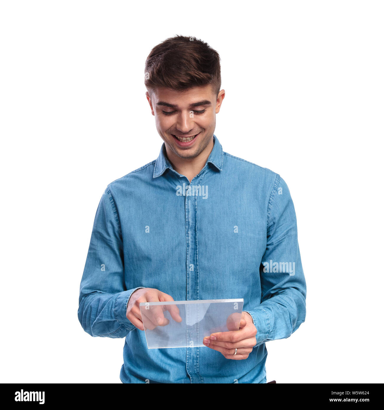 smiling casual man tapping on a futuristic gadget on white background ...