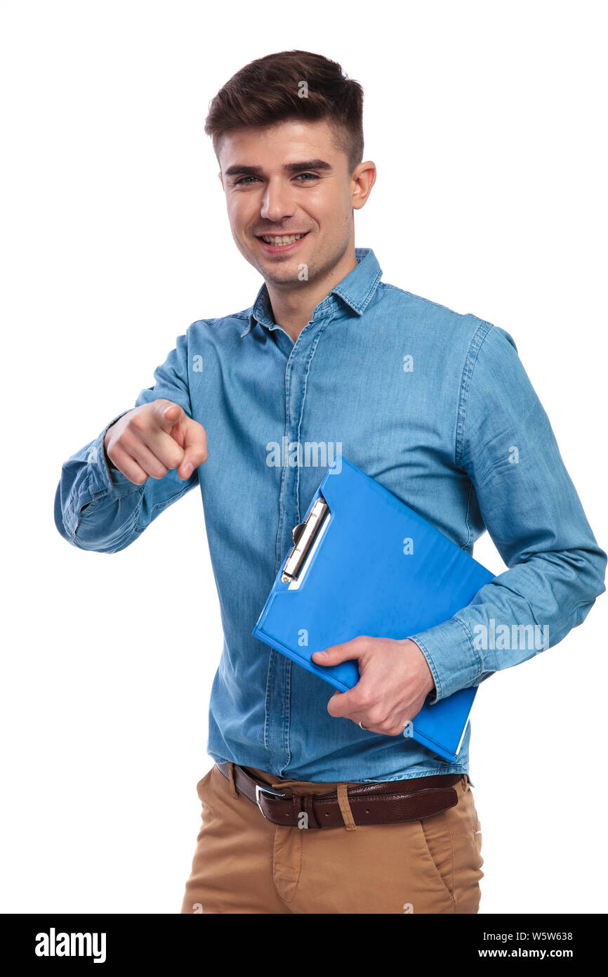 casual young man holding notepad is pointing finger to the camera on ...