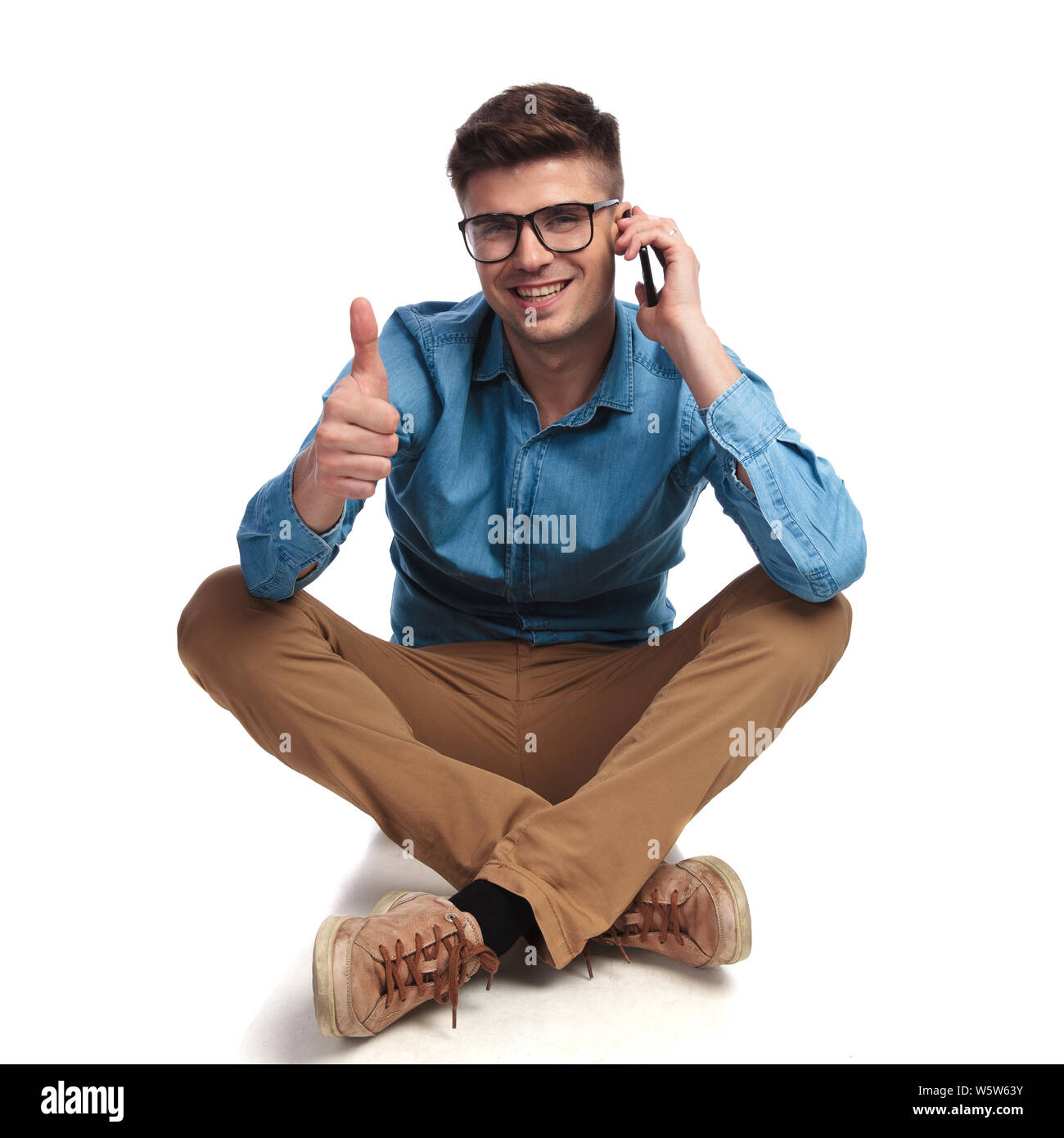 seated casual man talking on the phone makes the ok sign on white ...