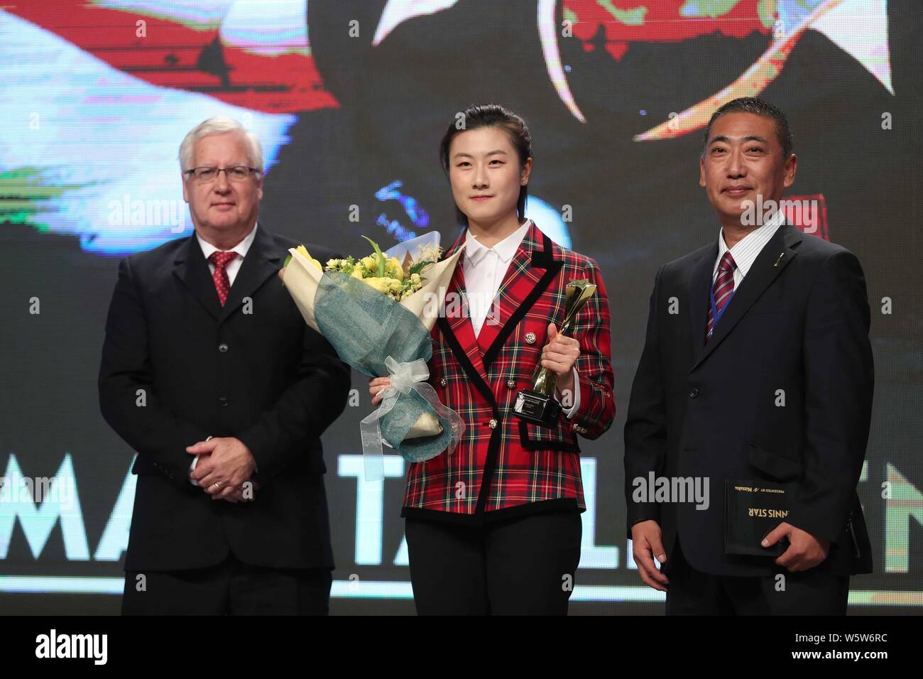 Chinese table tennis player Ding Ning, center, poses with her trophy ...