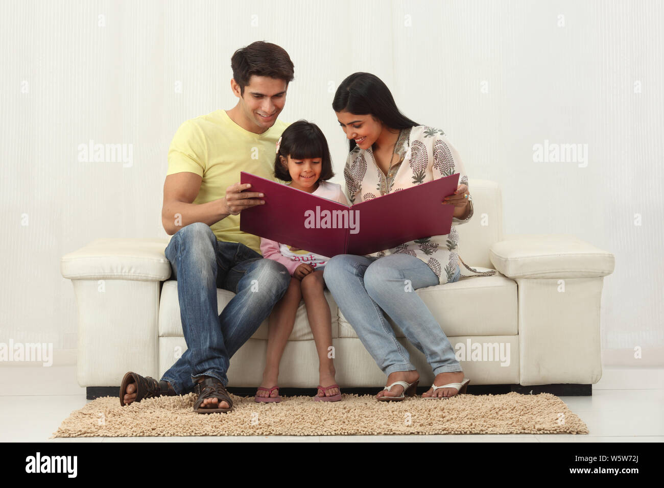 Family looking at family photo album Stock Photo - Alamy
