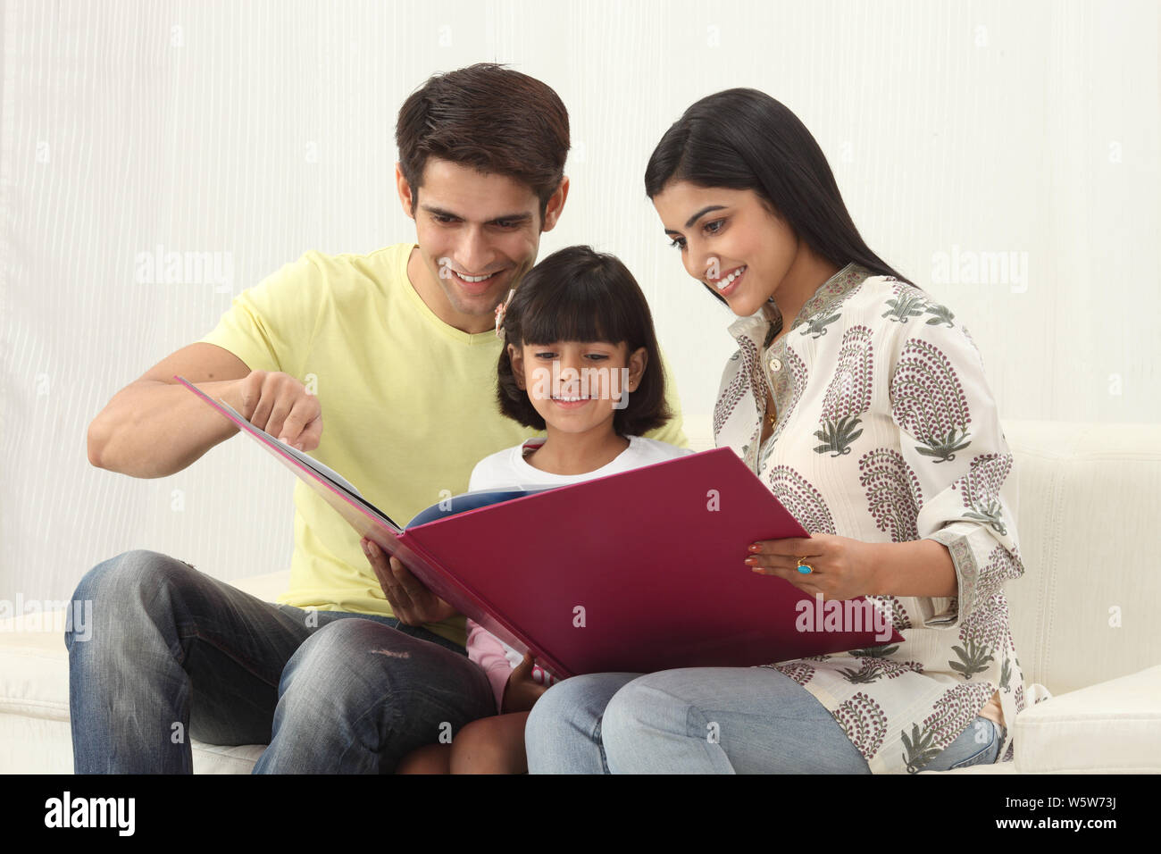 Family looking at family photo album Stock Photo - Alamy