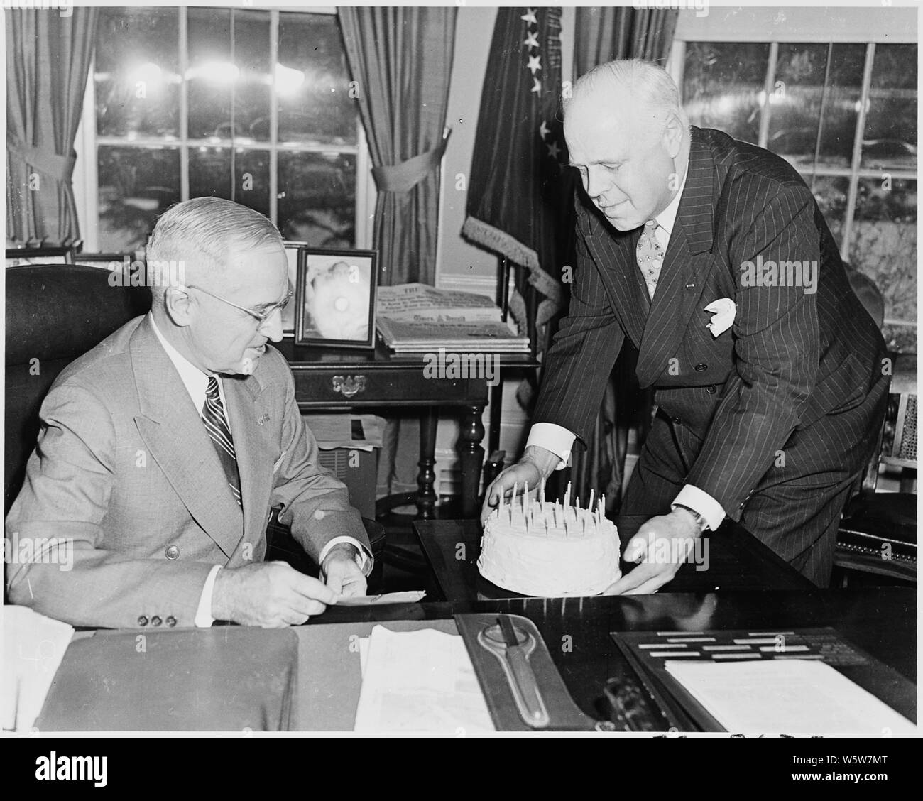 Photograph of President Truman receiving a birthday cake at his desk in ...