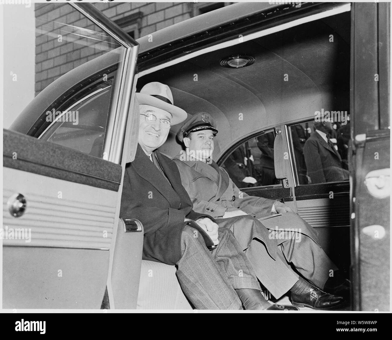 Photograph of President Truman sitting in the back of his limousine ...