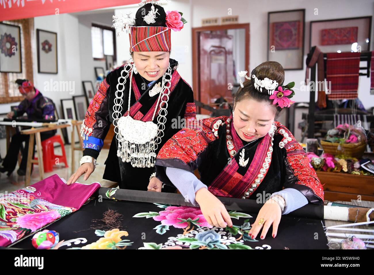 Chinese woman Liu Ying of Miao ethnic group instructs a craftswoman to ...
