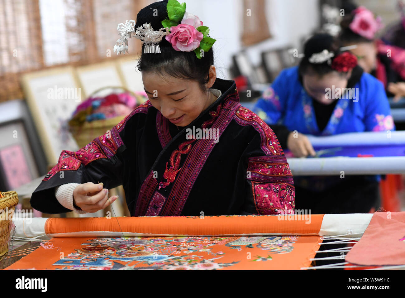 A craftswoman of Miao ethnic group creates an artwork of Miao ...