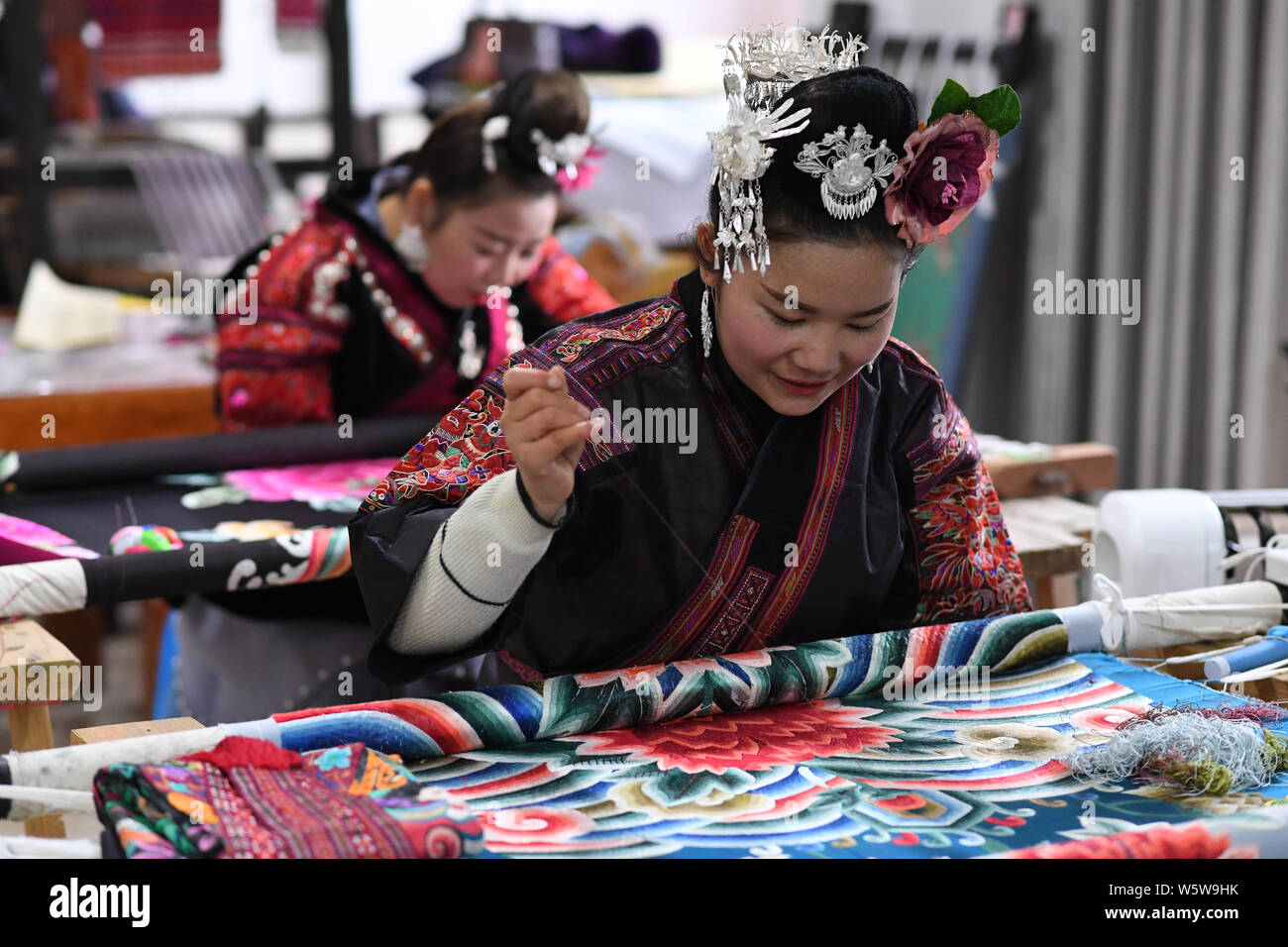 A craftswoman of Miao ethnic group creates an artwork of Miao ...