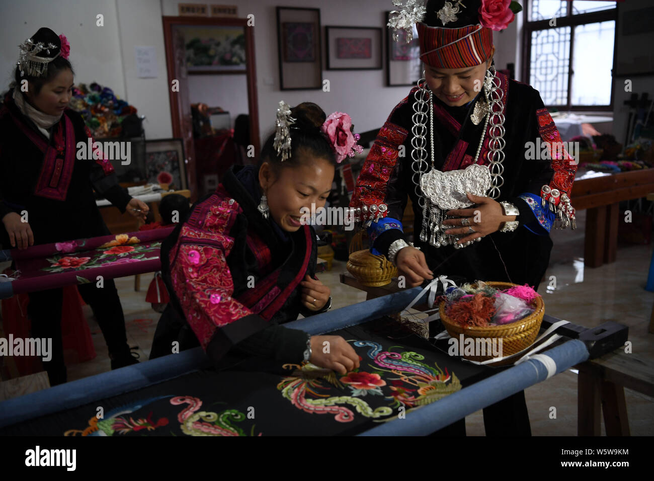 Chinese woman Liu Ying of Miao ethnic group instructs a craftswoman to ...