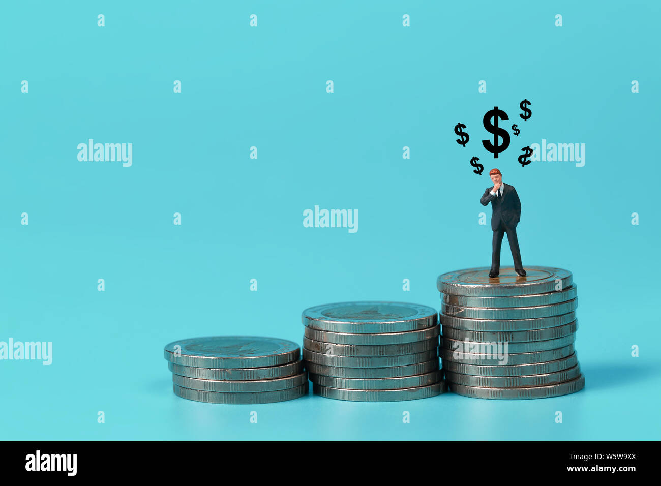 Miniature people: businessman standing on coin stacking podium with ...