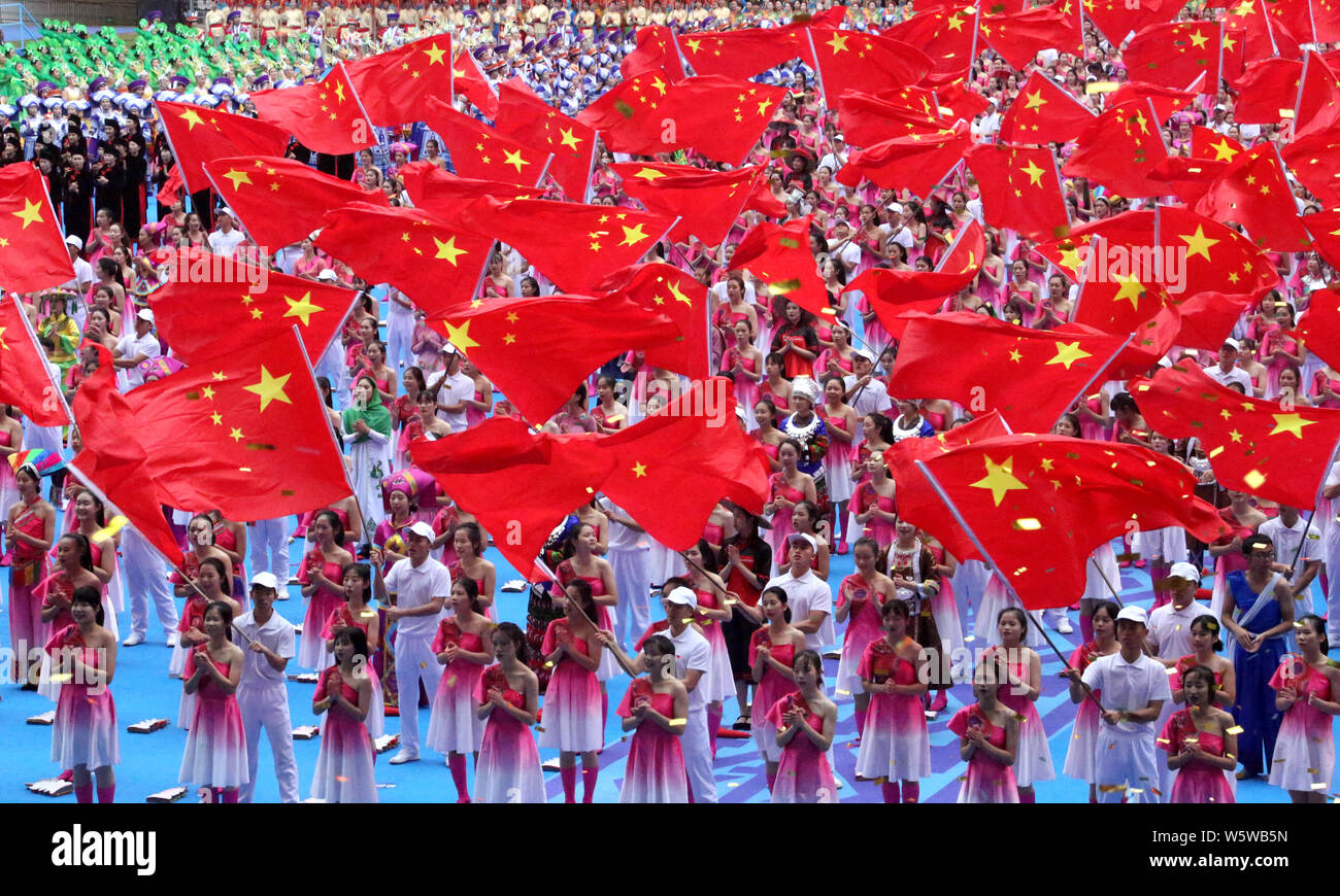 Dancers wave Chinese national flags during a grand gathering to ...