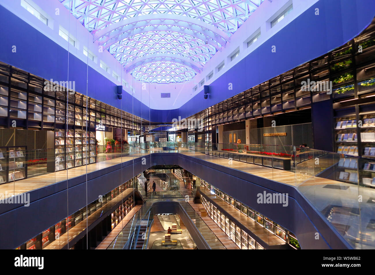 Books are placed on the four-storey-high book wall decorated with glass ...