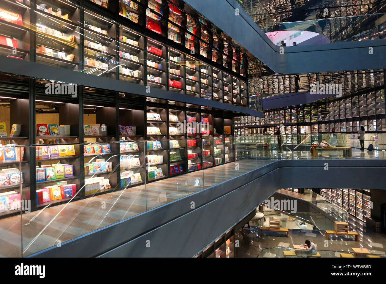 Books are placed on the four-storey-high book wall decorated with glass ...