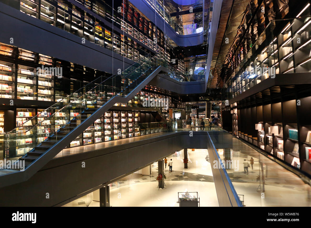 Books are placed on the four-storey-high book wall decorated with glass ...