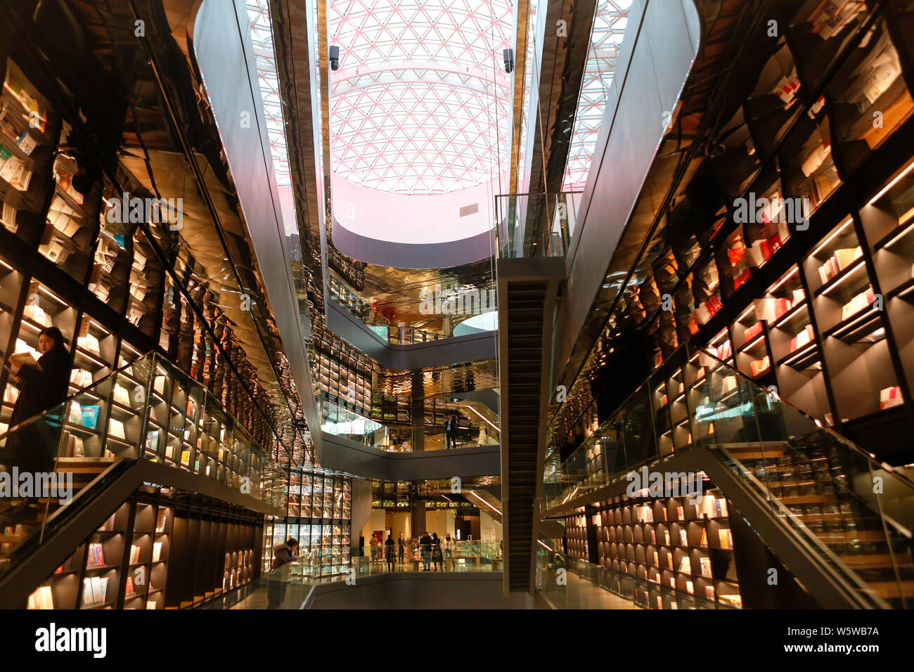 Books are placed on the four-storey-high book wall decorated with glass ...