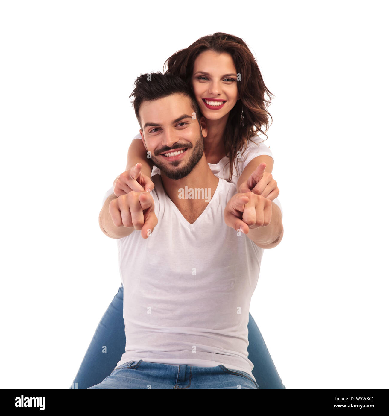 happy young couple pointing fingers together on white background Stock ...