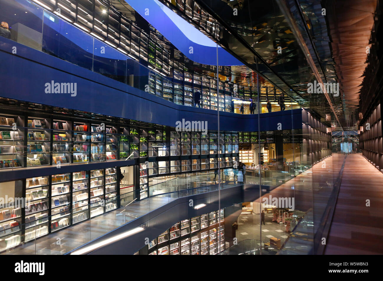 Books are placed on the four-storey-high book wall decorated with glass ...
