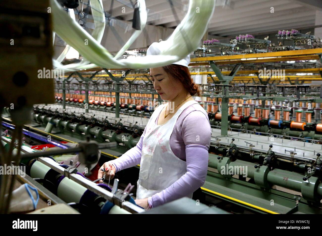 --FILE--A female Chinese worker handles production of yarn at a textile factory in Nantong city ...
