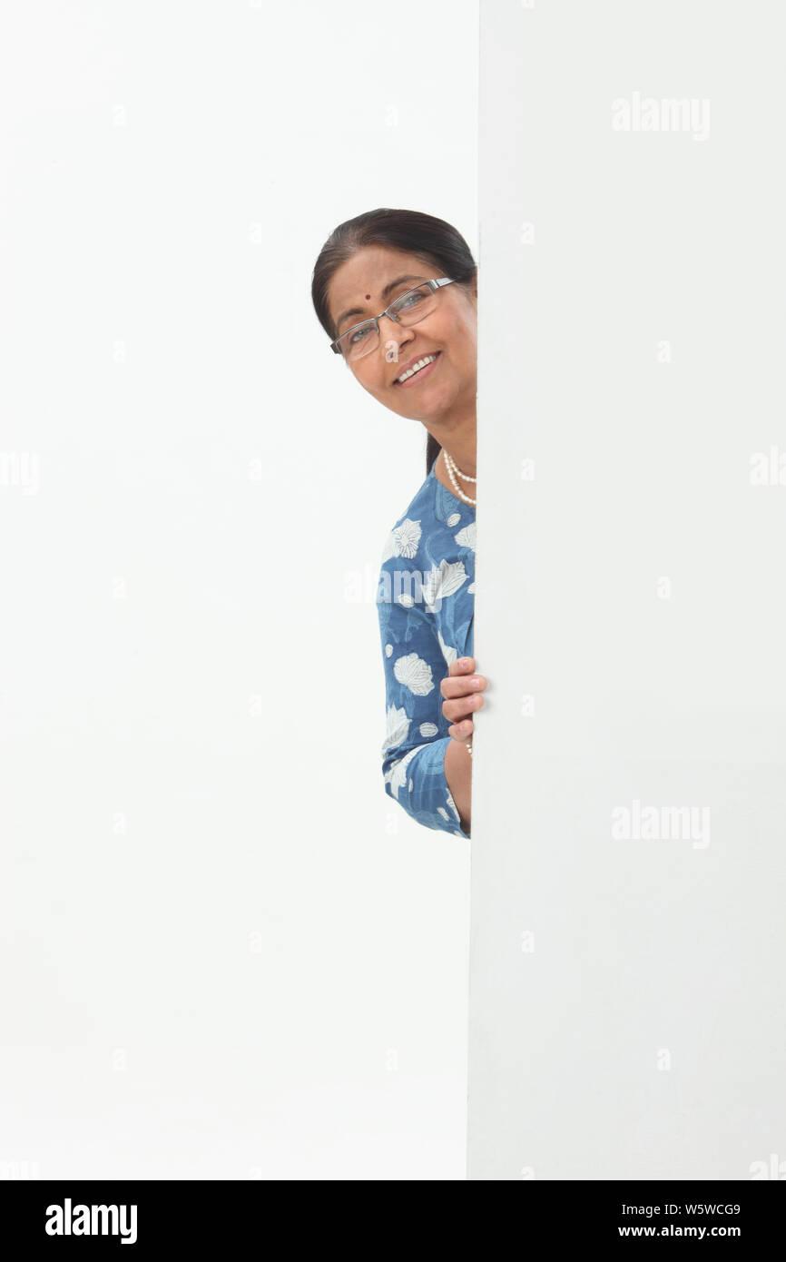 Old woman hiding behind a placard and smiling Stock Photo - Alamy