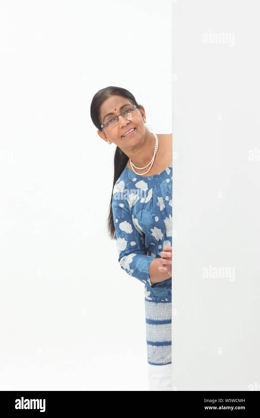 Old woman hiding behind a placard and smiling Stock Photo - Alamy