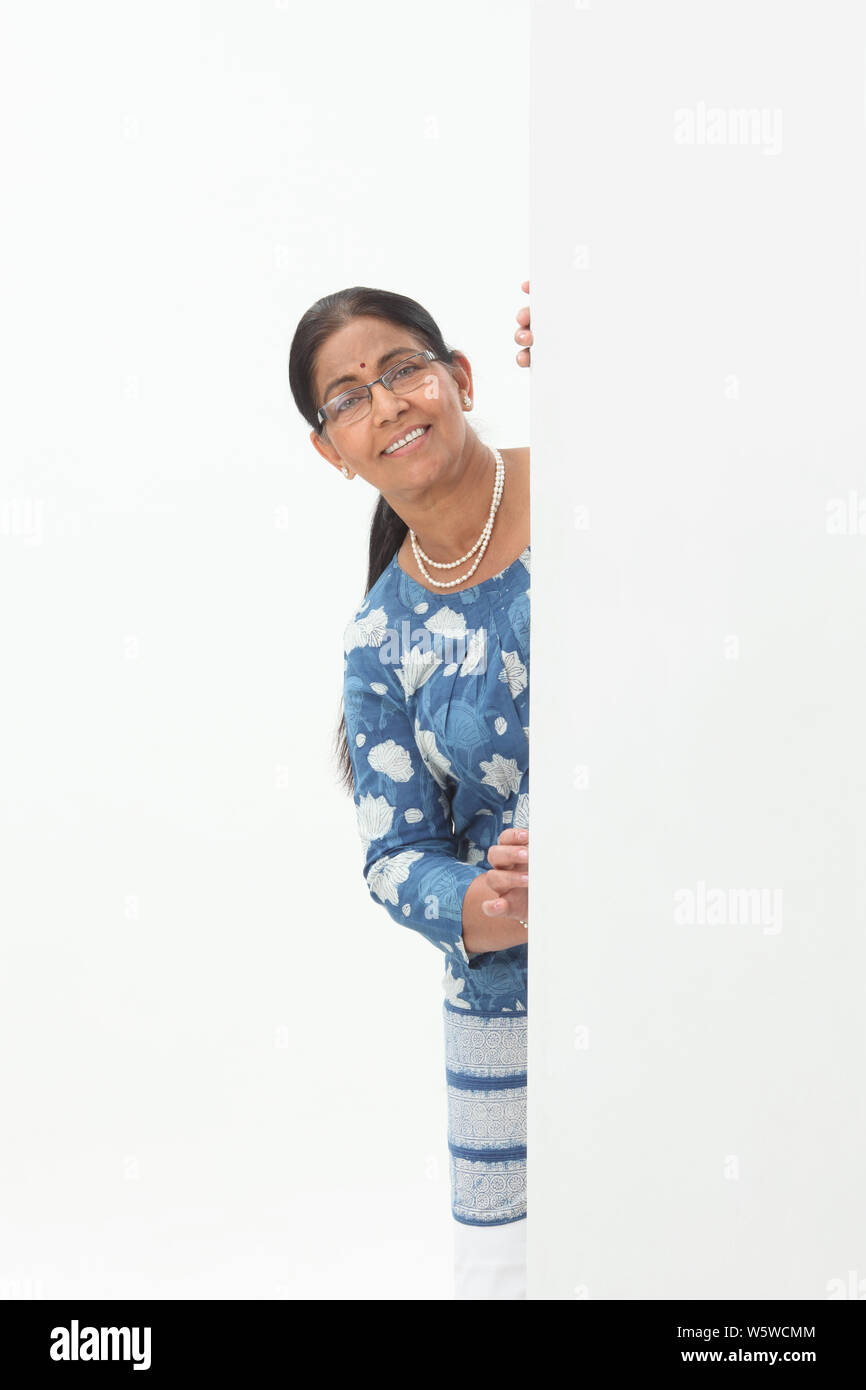 Woman hiding behind wall a watching High Resolution Stock Photography ...