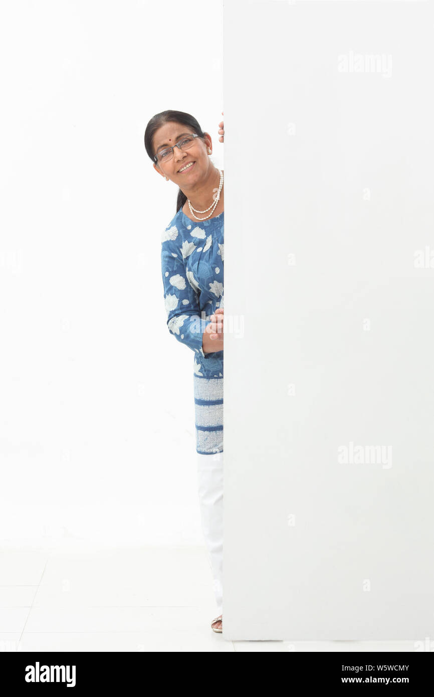 Old woman hiding behind a placard and smiling Stock Photo - Alamy