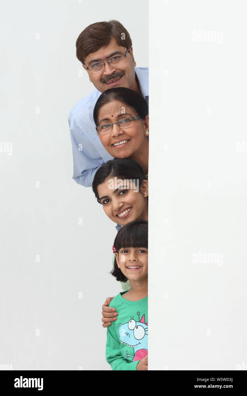 Family hiding behind a placard Stock Photo - Alamy