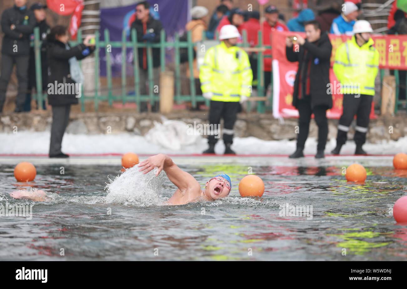 A Chinese contestant competes in the freezing water during a winter ...
