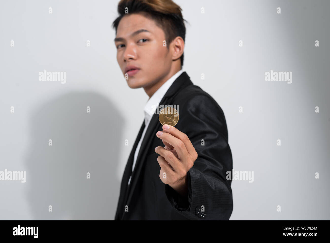 Asian Man in black suit holding Bitcoin on white background Stock Photo ...